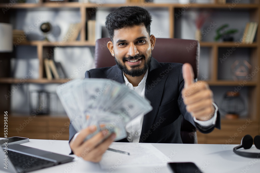 Portrait of happy young attractive male accountant holding cash ...