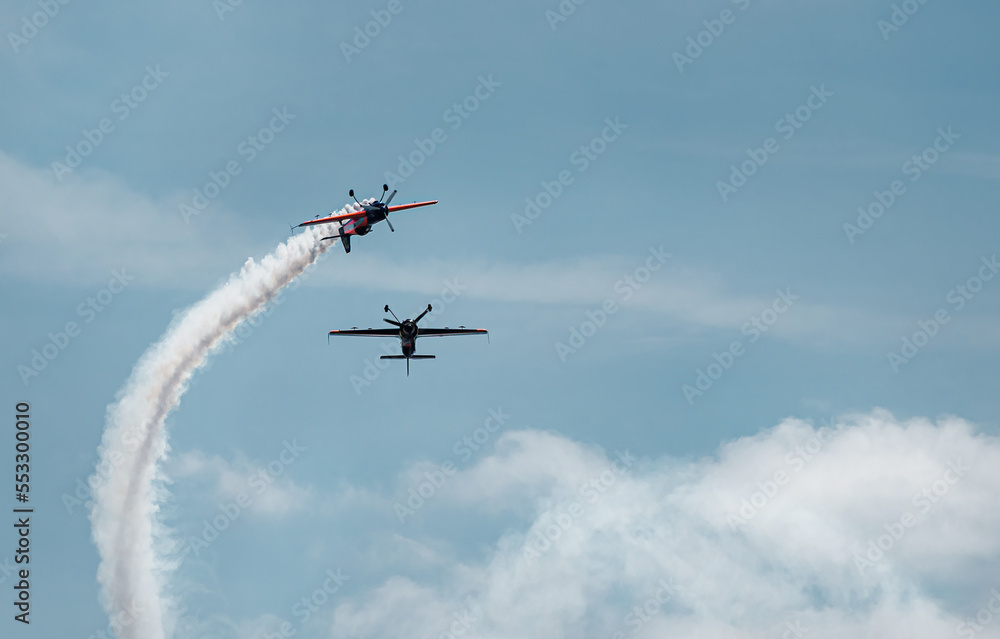 Foto de two planes cross dangerously in the blue sky, leaving a trail ...