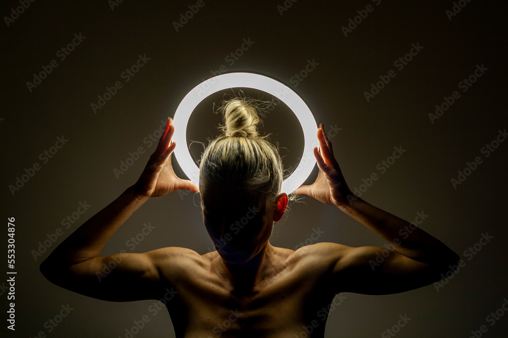 Blonde woman without clothes, only with a light ring showing her ...