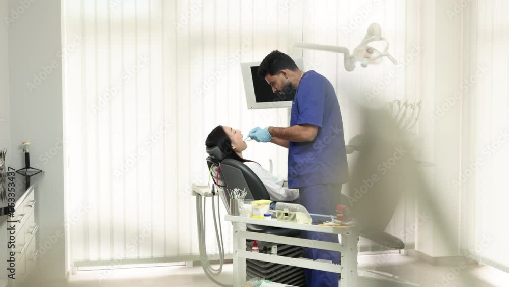 Side view of bearded male doctor in white uniform and gloves, making ...