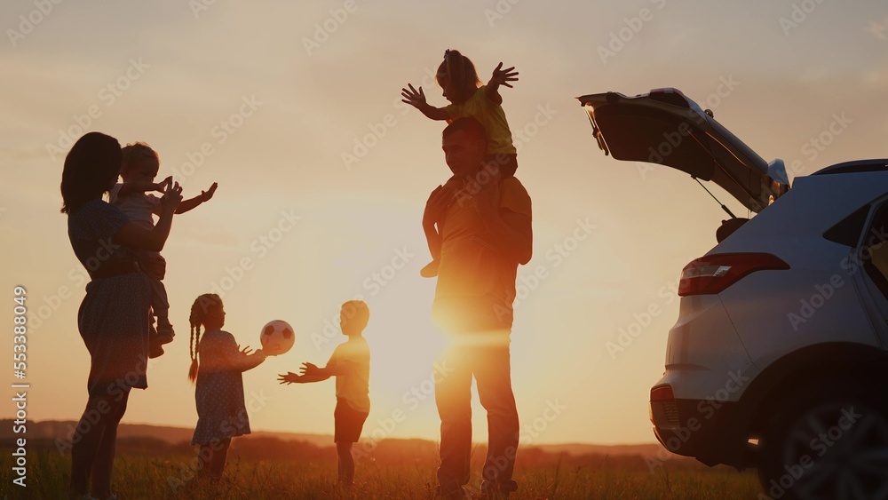 happy family. children stand together next to the car silhouette of the ...