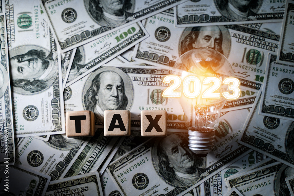 Light bulb, Tax word on business background and tax concept 2023 tax ...