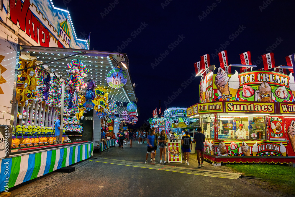 Nighttime at carnival county fair with vendors of games and food Stock ...