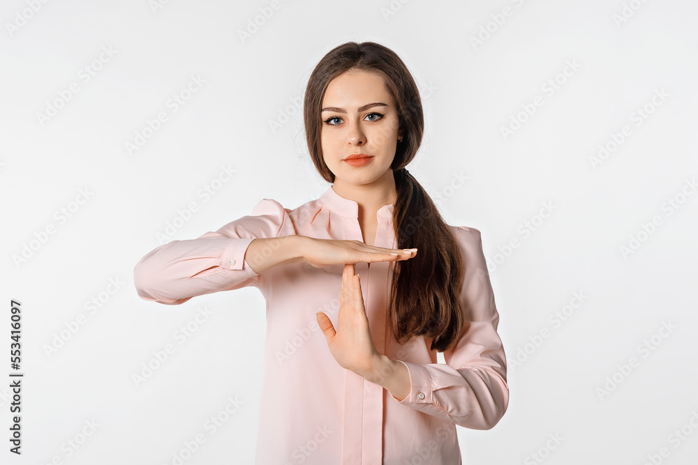 Young woman showing time out hand gesture to stop something, standing ...