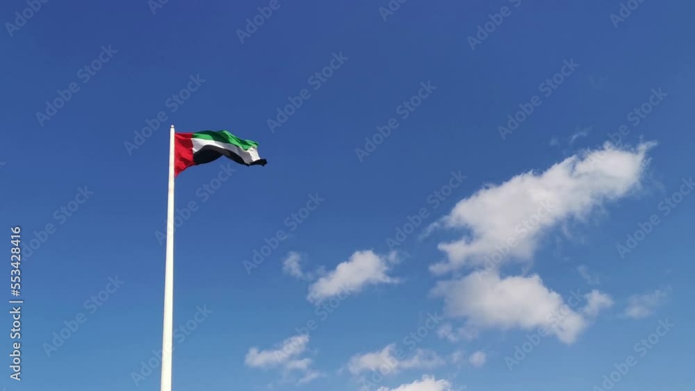 United Arab Emirates National flag waving in wind. UAE flag in blue sky ...