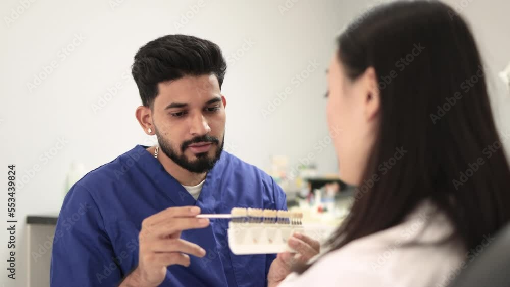 Tooth teeth tone palette. Confident bearded male cosmetologist orthodontist dentist choosing ...