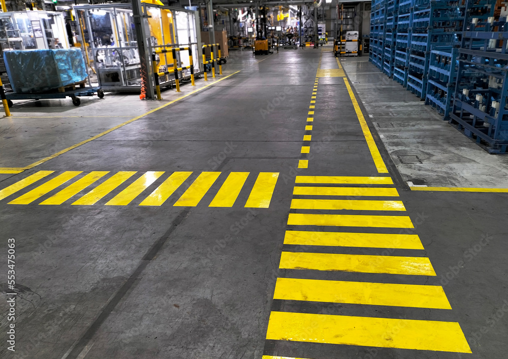 Industrial building corridor painted yellow between parallel yellow ...