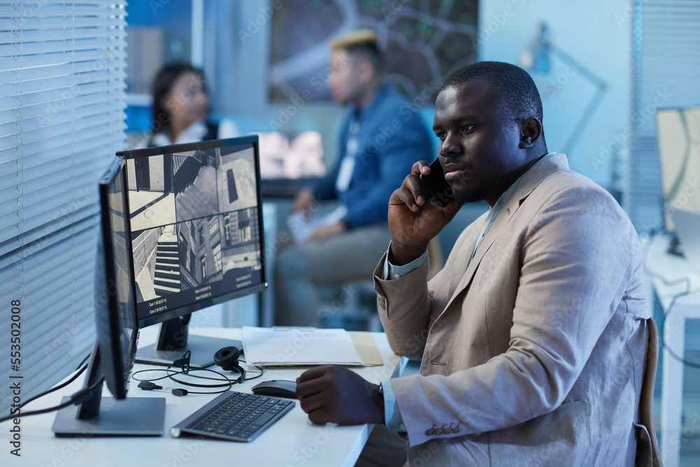 Side view portrait of black man speaking on phone and looking at ...