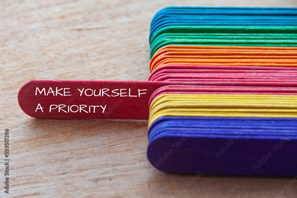 Make yourself a priority text on red wooden stick sticking out ...