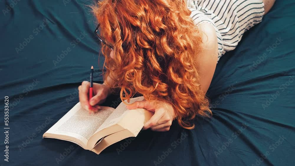 woman studies lying on the bed trying to memorize the salient concepts ...