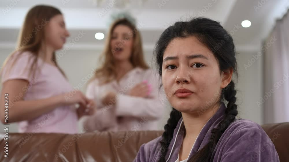 Close-up depressed sad Asian woman looking at camera as blurred ...