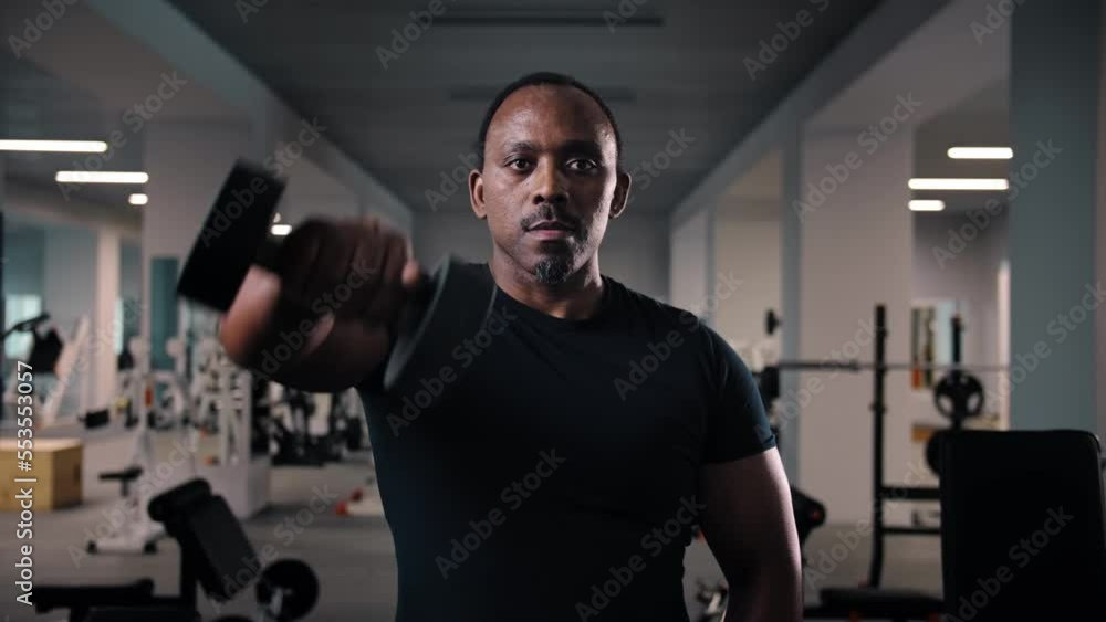 Black man workout with dumbbell training shoulders in gym.Bodybuilder ...