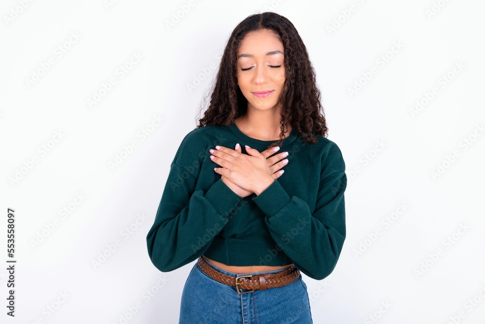 teen girl wearing knitted green sweater over white closes eyes and ...