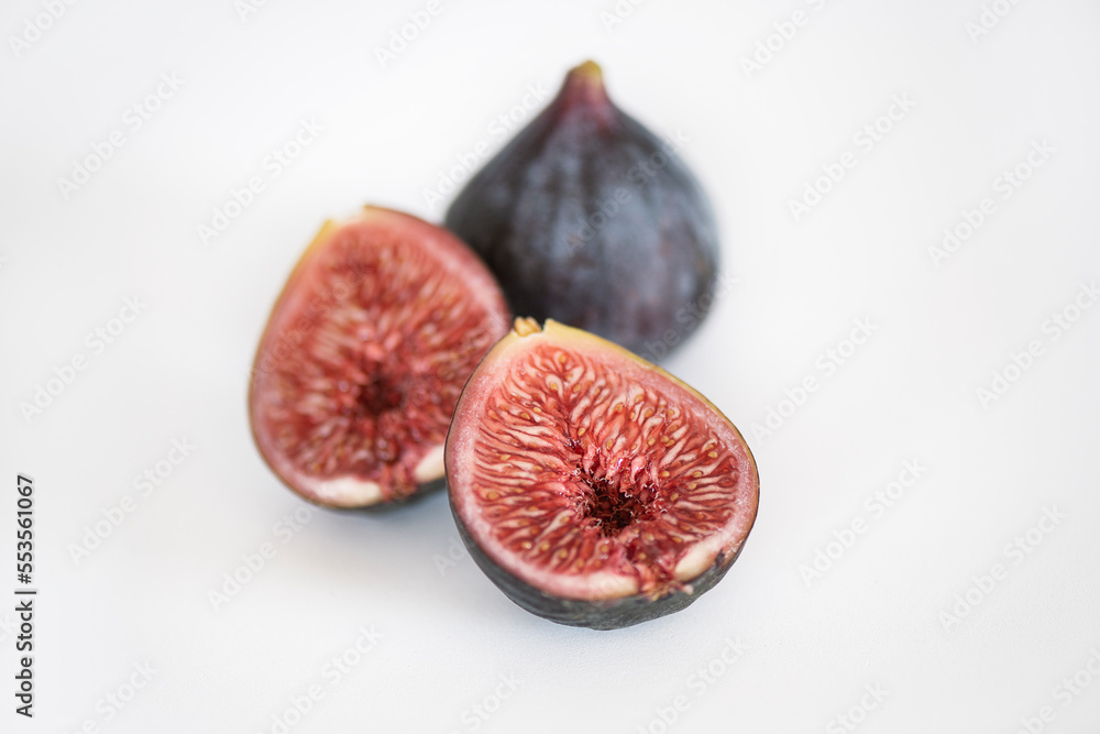 Isolated Black Mission Figs One Whole And One Halved Positioned On A