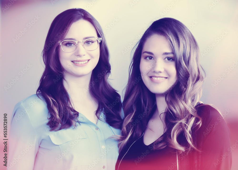 Two young woman who are friends, posing for a portrait which has been ...