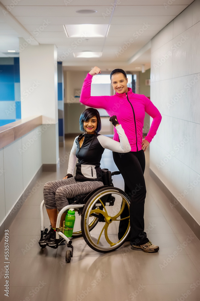 A paraplegic woman and her trainer show off their muscles while posing ...