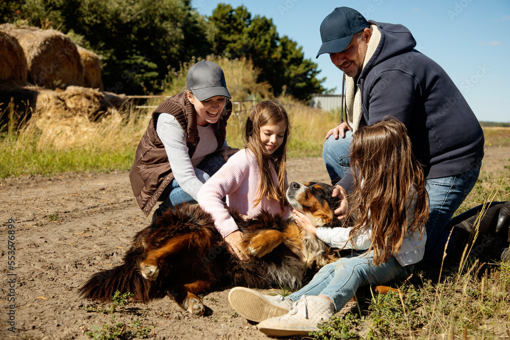 Parents crouching down next to their two young girls that are sitting ...