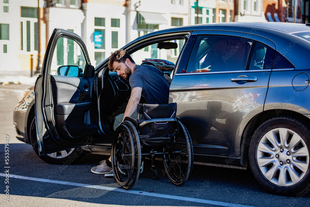 Young paraplegic man moves from his wheelchair to the driver's seat of ...