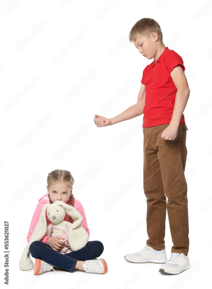 Boy with clenched fist looking at scared girl on white background ...
