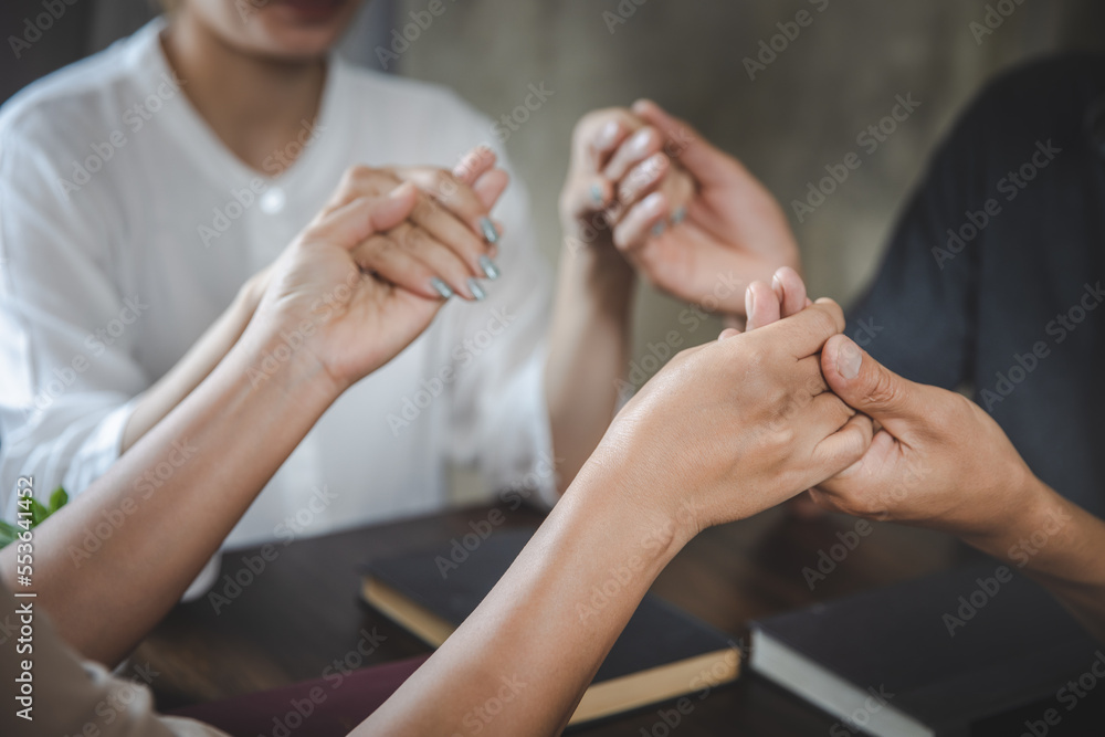 A group of Asian Christians sits inside a Catholic Church praying for ...