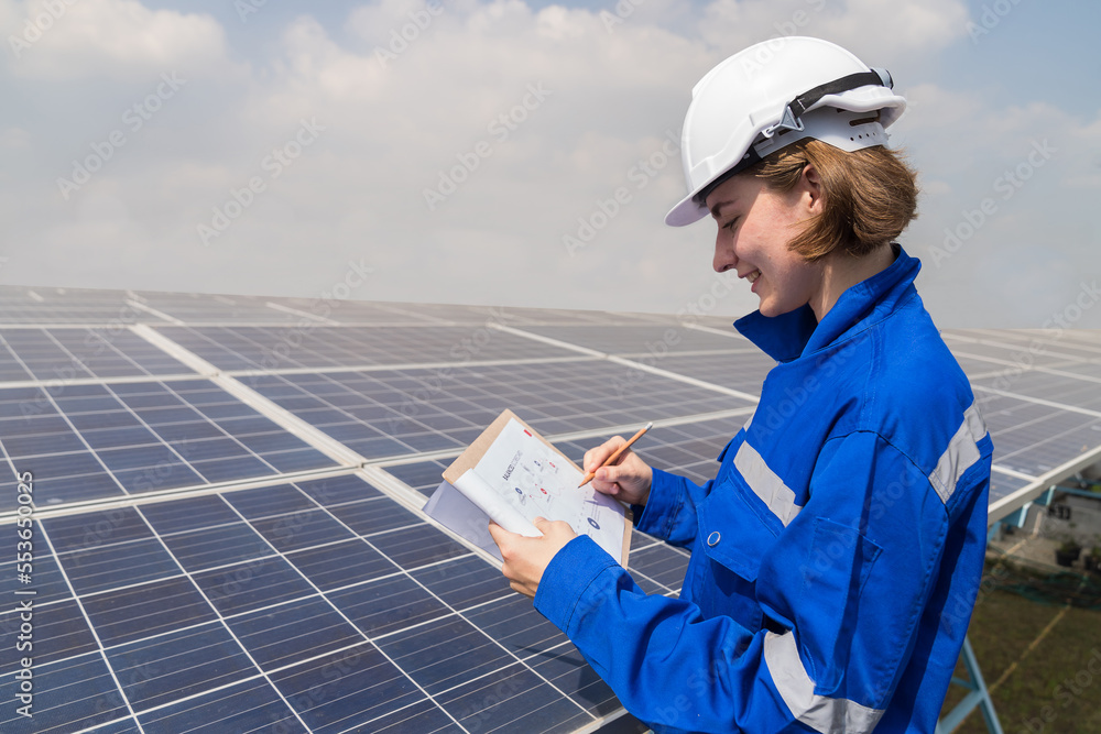 Female electrician worker in safety uniform working in solar panels ...
