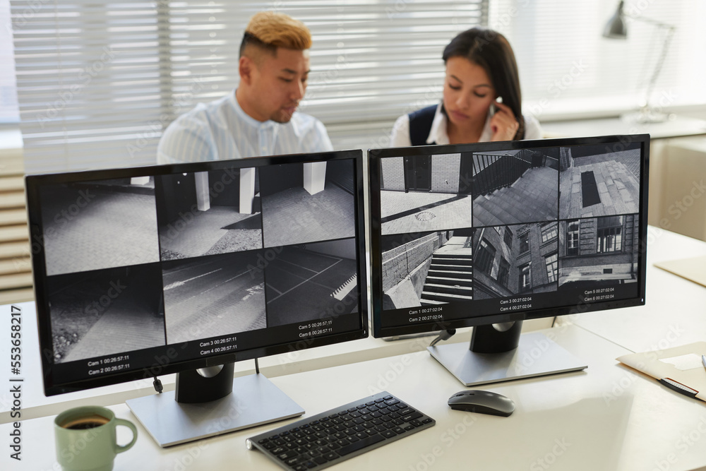 Background image of two computer screens with multiple surveillance ...