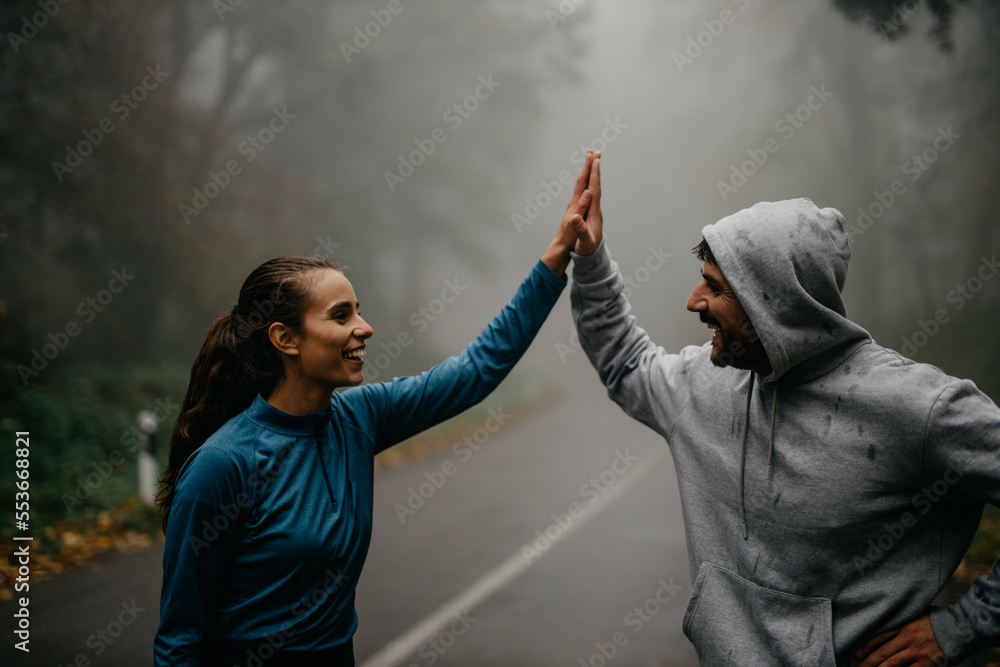 Two people in sports outfits have an active HIIT workout in the forest ...