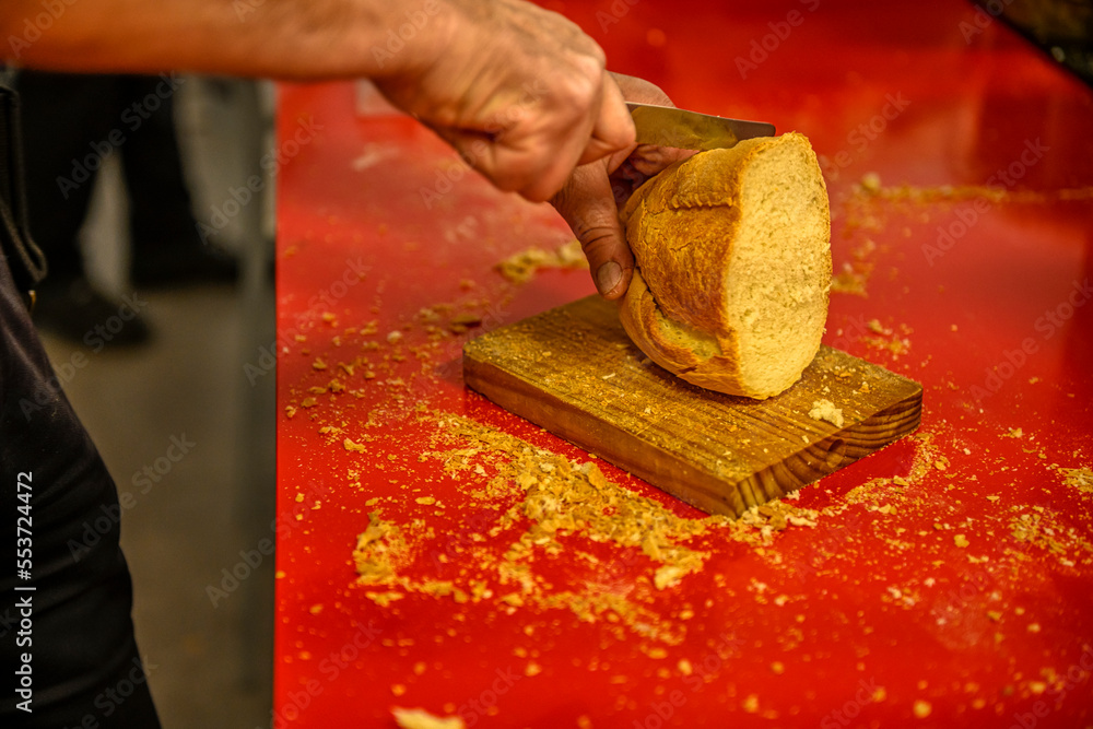 Cut a loaf of bread into smaller portions. Stock Photo | Adobe Stock