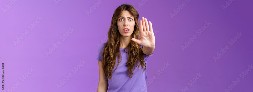 Worried shocked curly-haired woman gasping stare camera anxiously pull ...