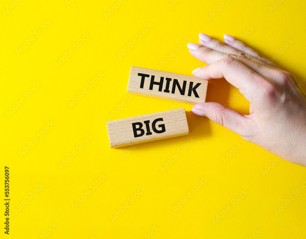 Think big symbol. Wooden blocks with words Think big. Beautiful yellow ...