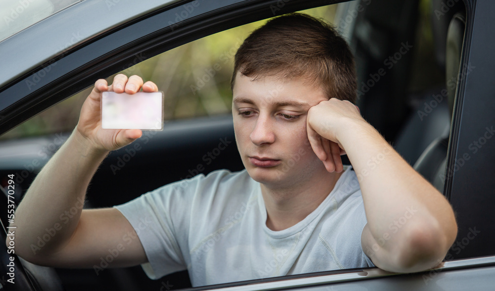 Upset driver showing his driver license out of the car window as for ...