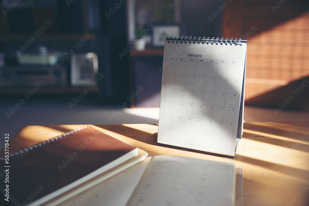 Desktop calendar, and planner book placed on student wooden desk in ...