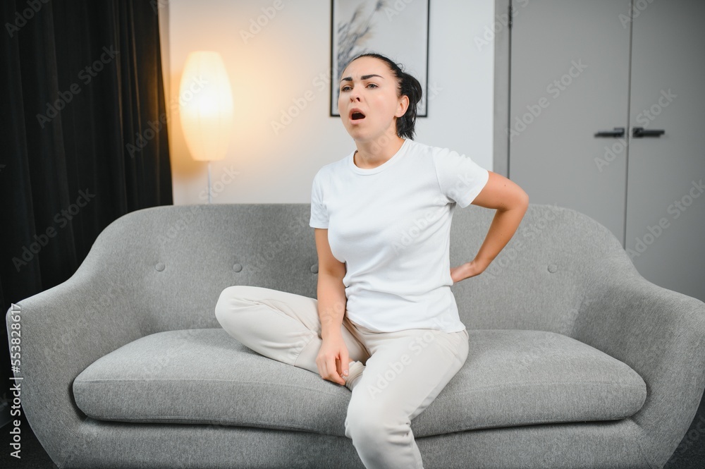 Sad young woman touching back feeling backache morning discomfort low ...