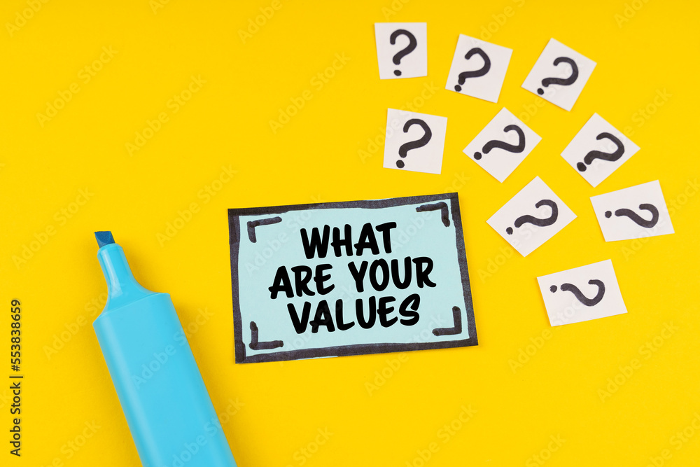 On the yellow surface is a marker, question marks and a sticker with ...