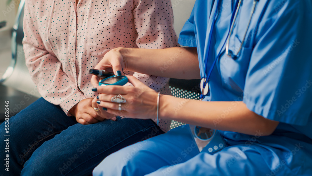 Nurse doing insulin level measurement with glucometer to help patient ...