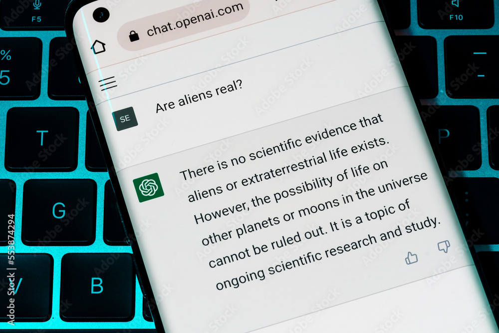 OPEN AI ChatGPT chat bot seen on smartphone placed on laptop. AI ...