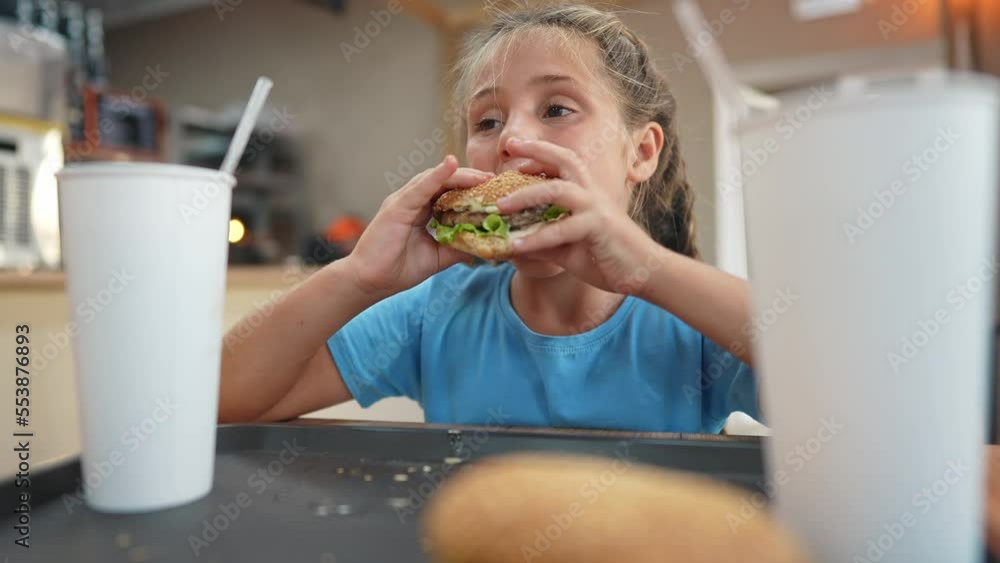 child kid eating a burger in a cafe. fast food nutrition health concept ...