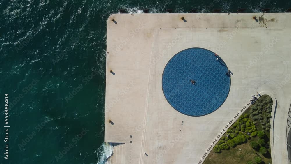 Minimal people and geometrical shapes by the sea. Directly above ...