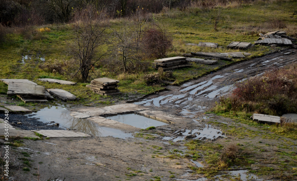 muddy road with lots of concrete obstacles and traps in a war zone ...