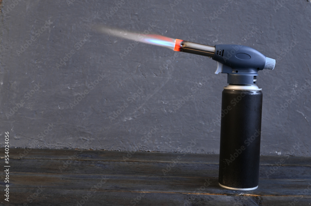 fire from the nozzle of a gas soldering iron put on a tourist gas ...
