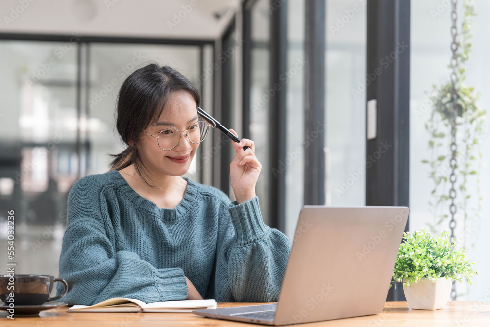 Foto de Beautiful women student studying online takes notes on her ...