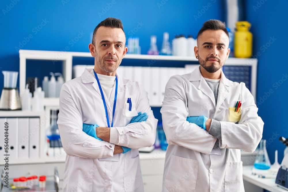 Two men scientists standing with relaxed expression and arms crossed ...