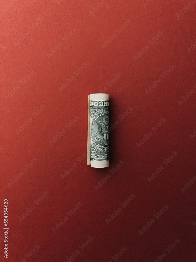 Shot of the one dollar us banknote. Rolled 1 dollar us on a red ...