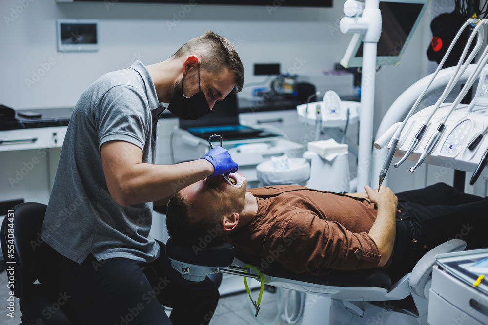 Orthodontic treatment of teeth. A young man at a dentist's appointment ...