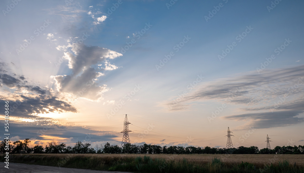 Power transmission lines transfer clean energy. Sunset illuminates ...