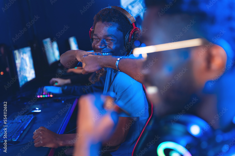 Professional african cyber gamer greeting and support team fists hands ...