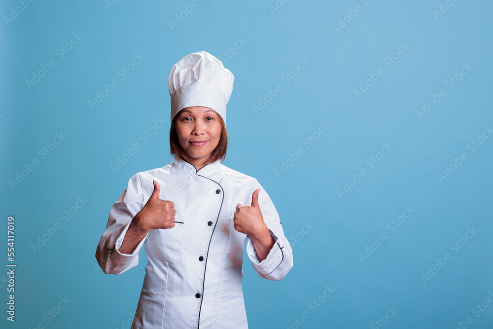 Friendly positive cook doing thumbs up gesture approving gastronomy ...