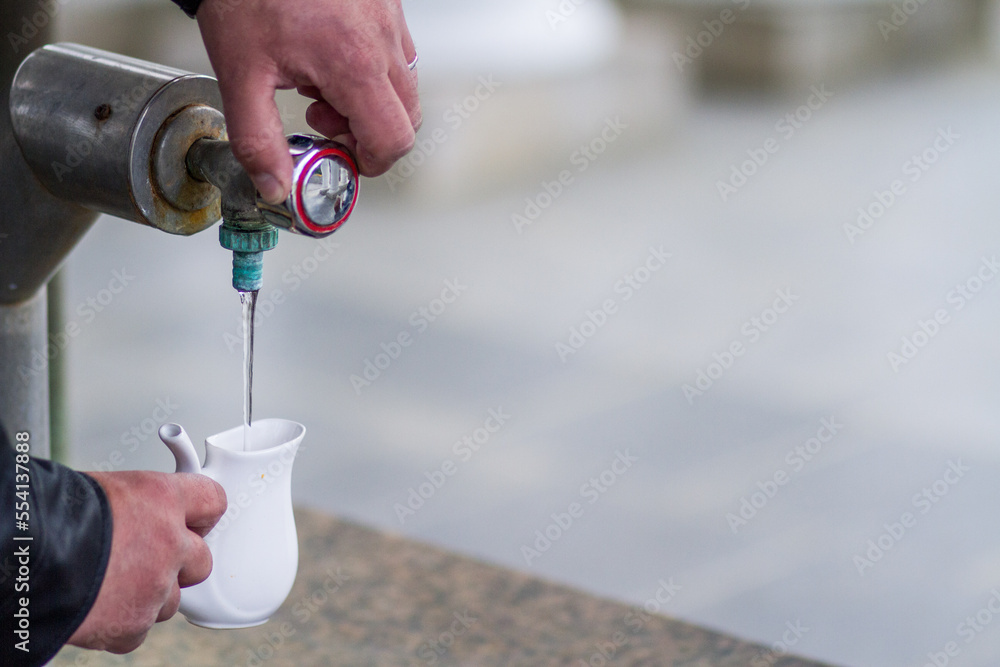 pouring healing spring water into cup in spa town Stock Photo | Adobe Stock