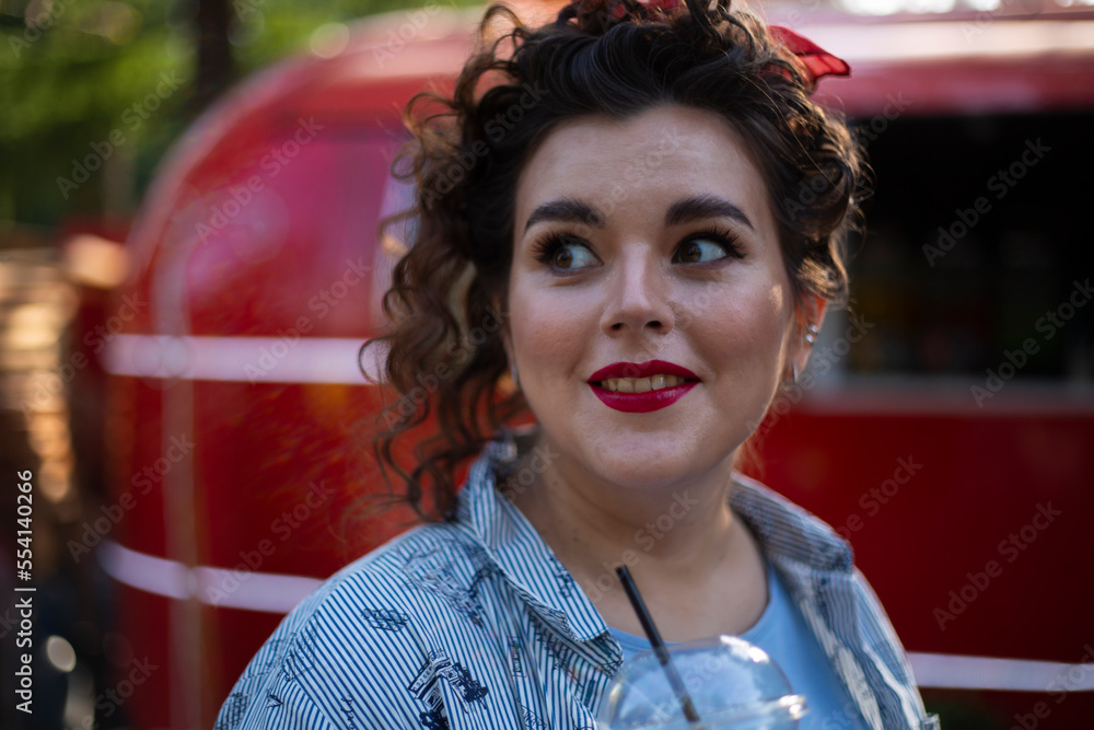 Young beautiful pinup woman with curly hair smiles and looks to future ...