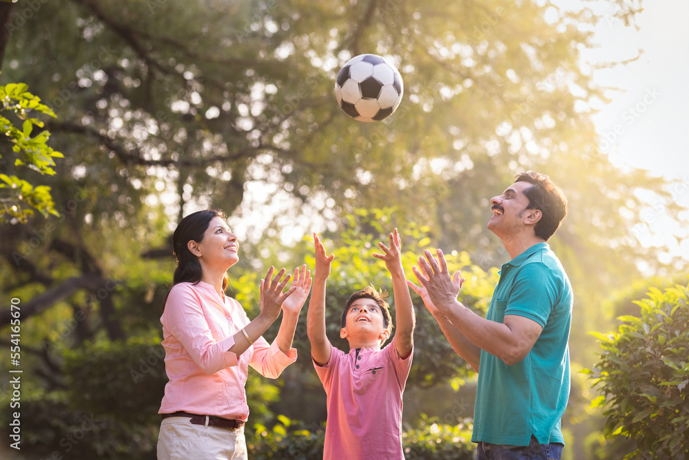 Happy indian family playing with football at park Stock Photo | Adobe Stock